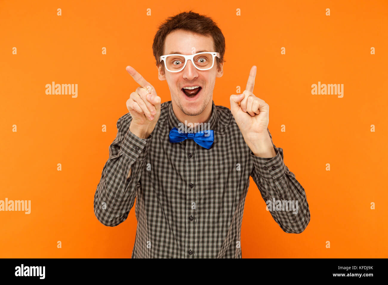 Hey, looking up! Amazement man pointing fingers up. Studio shot ...
