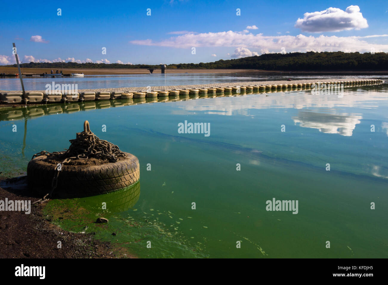 Tyre anchor on the shore of a reservoir with receding water line at ...