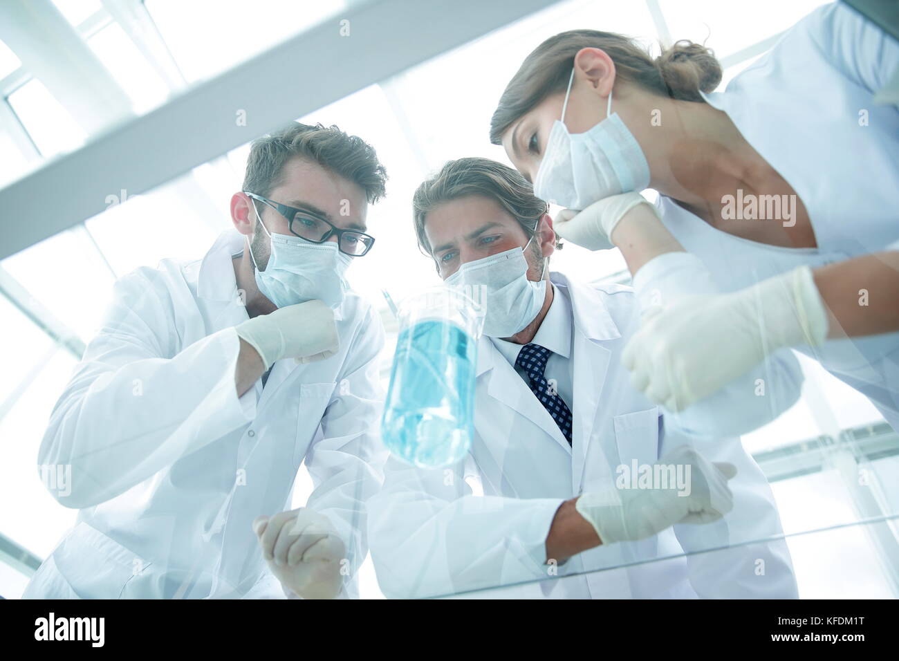 Scientists in the laboratory wearing protective goggles, looking at the ...