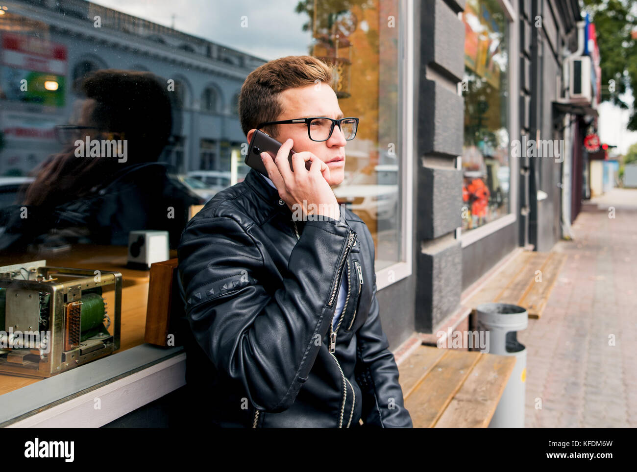 man in the jacket on the street talking on a cell phone Stock Photo - Alamy