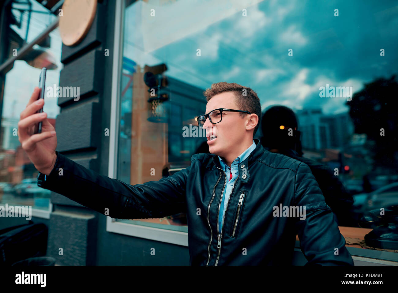man in the jacket on the street talking on a cell phone Stock Photo - Alamy