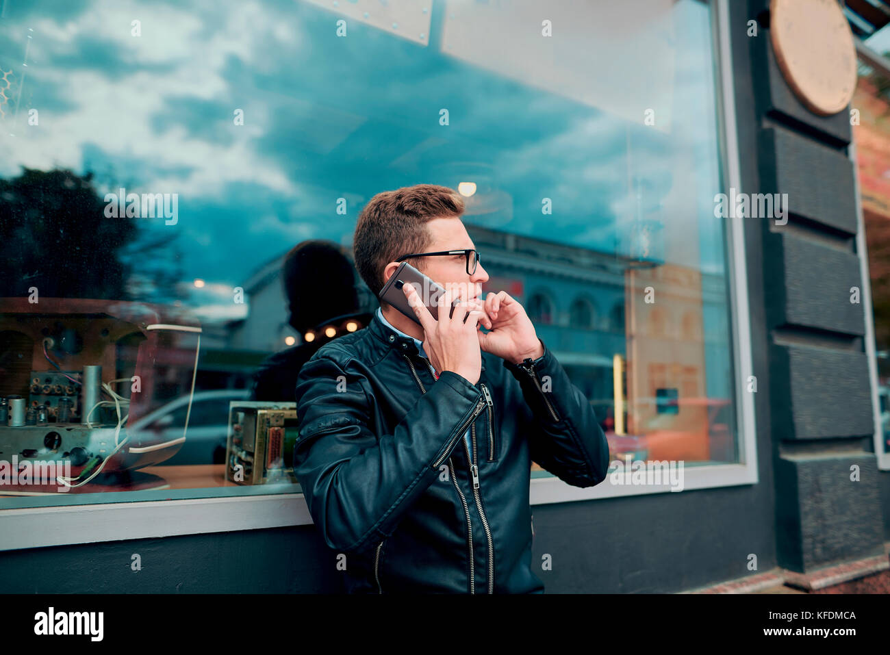 man in the jacket on the street talking on a cell phone Stock Photo - Alamy
