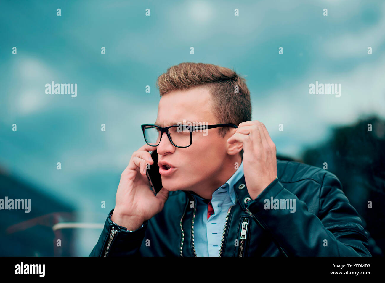 man in the jacket on the street talking on a cell phone Stock Photo - Alamy