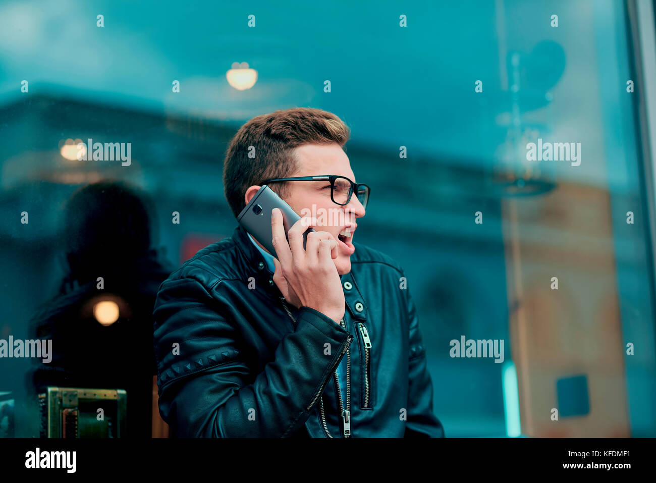 man in the jacket on the street talking on a cell phone Stock Photo - Alamy