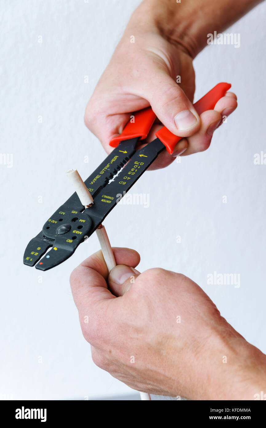 Close-up of a human hand is removed the insulation from the coaxial ...