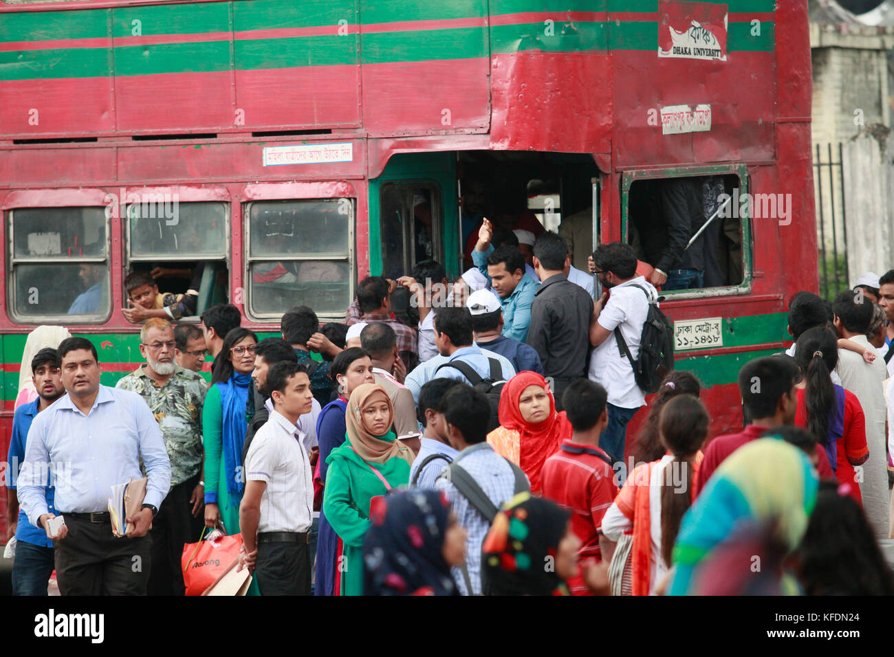 Bangladeshi people try to ride in of an overcrowded bus to travel home ...