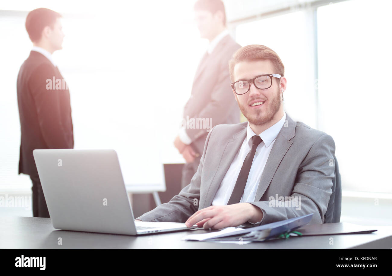 in the foreground is a successful businessman sitting at the table in ...