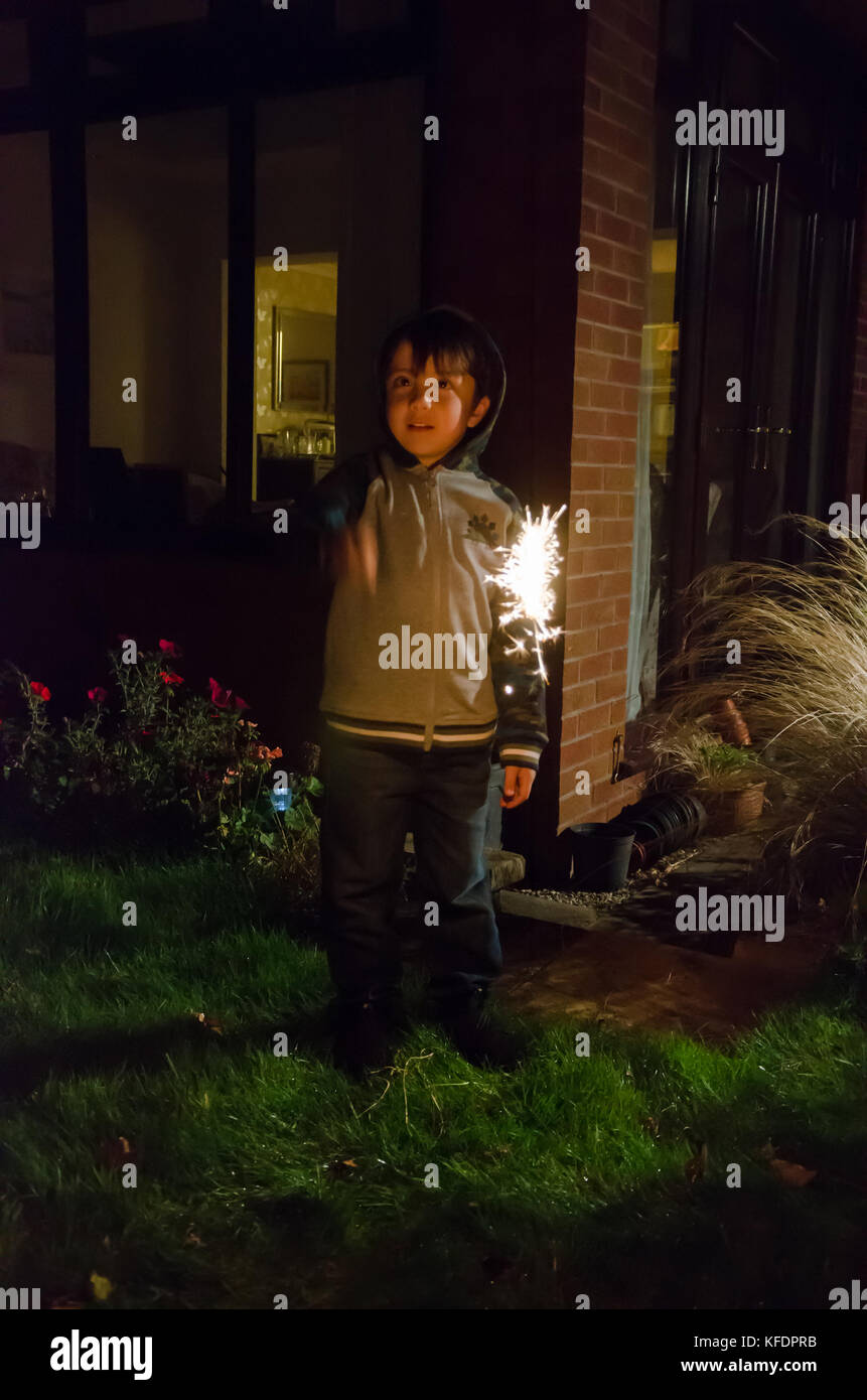 A young boy playing with a sparkler in the back garden Stock Photo - Alamy