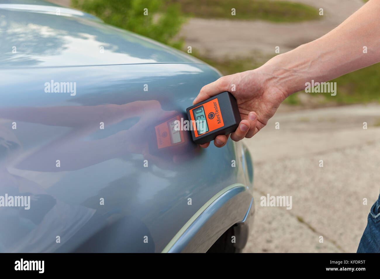 checking the body and doors of the car, the man measures the car's body ...