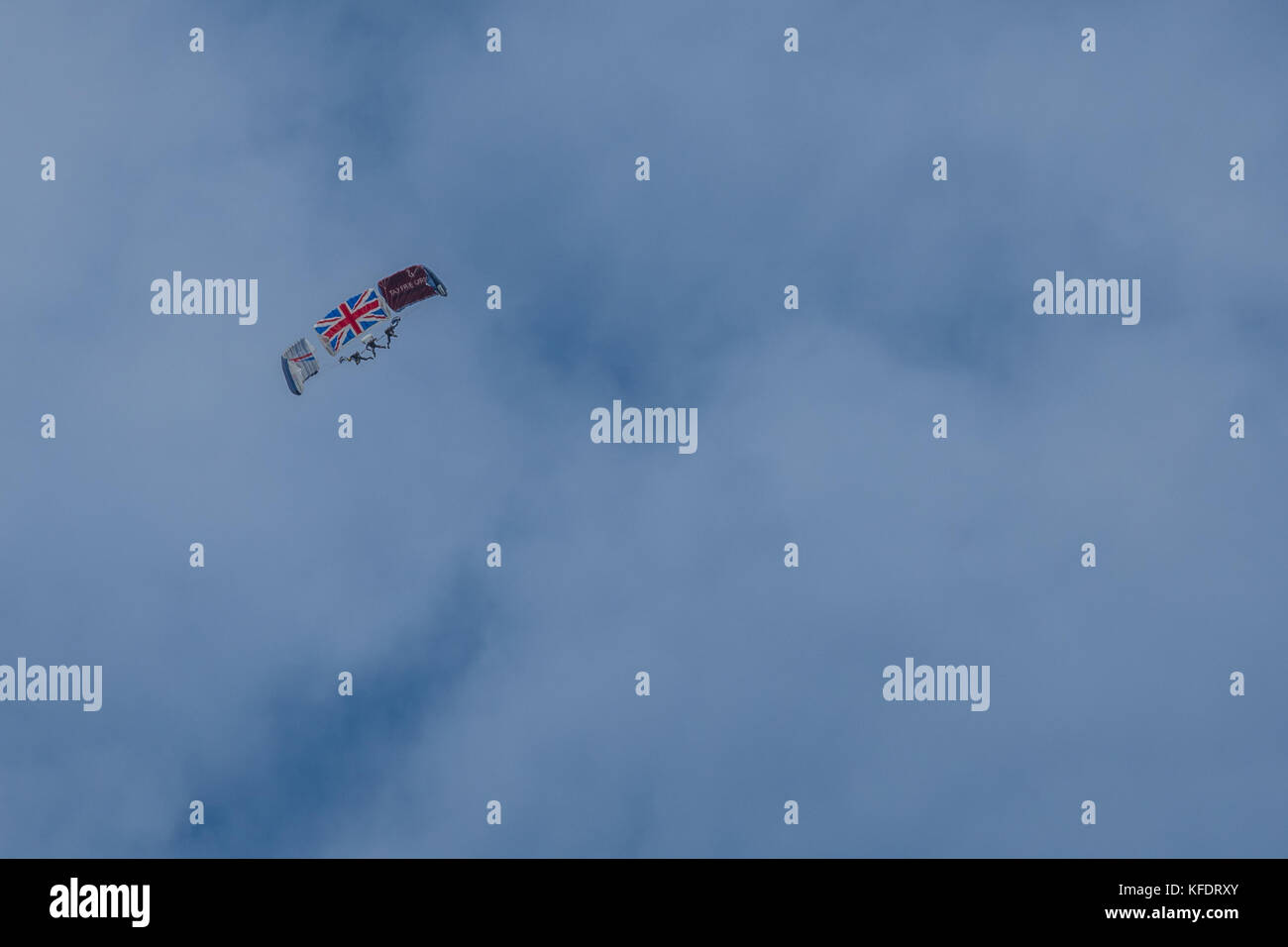 Parachute display team drop through blue sky showing the Union Jack ...