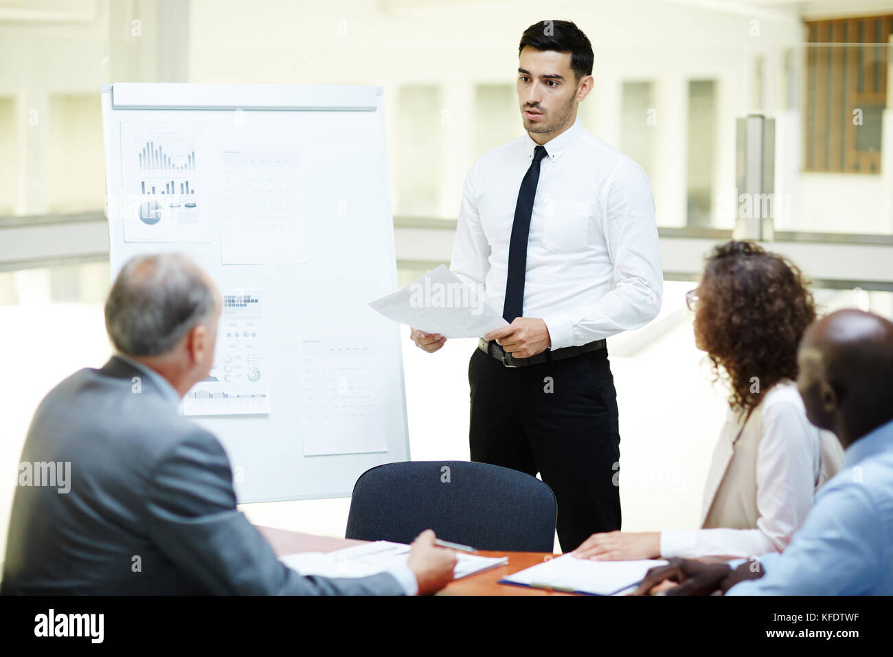 Young confident employee presenting his ideas and strategies on ...