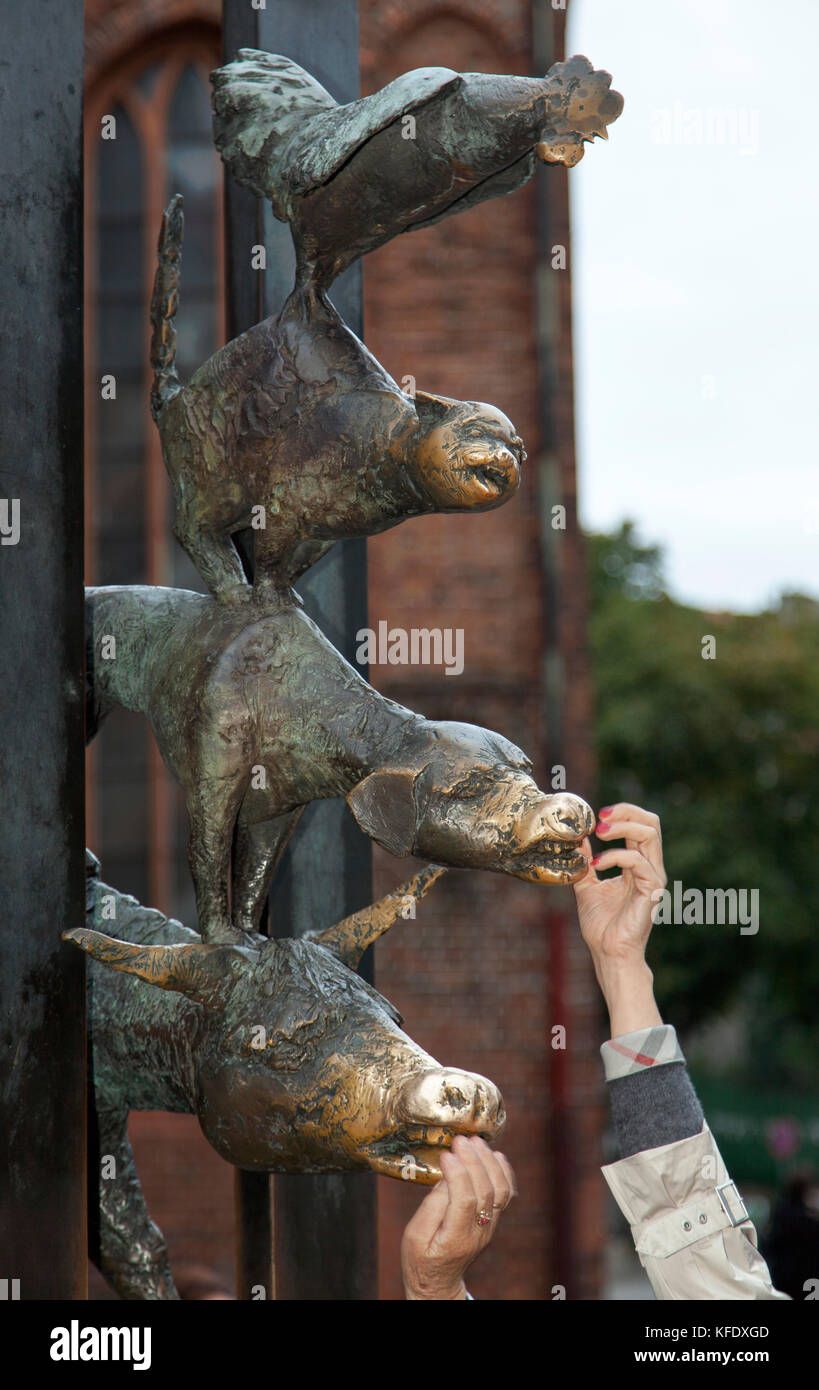 Numerous tourists touching daily the musicians of Bremen, the ...