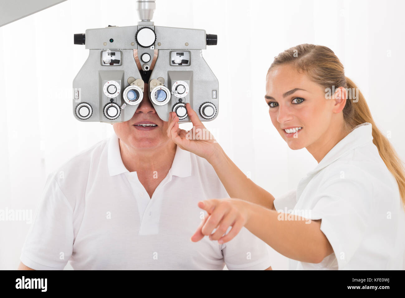 Happy Female Optometrist Doing Sight Testing For Patient In Clinic ...