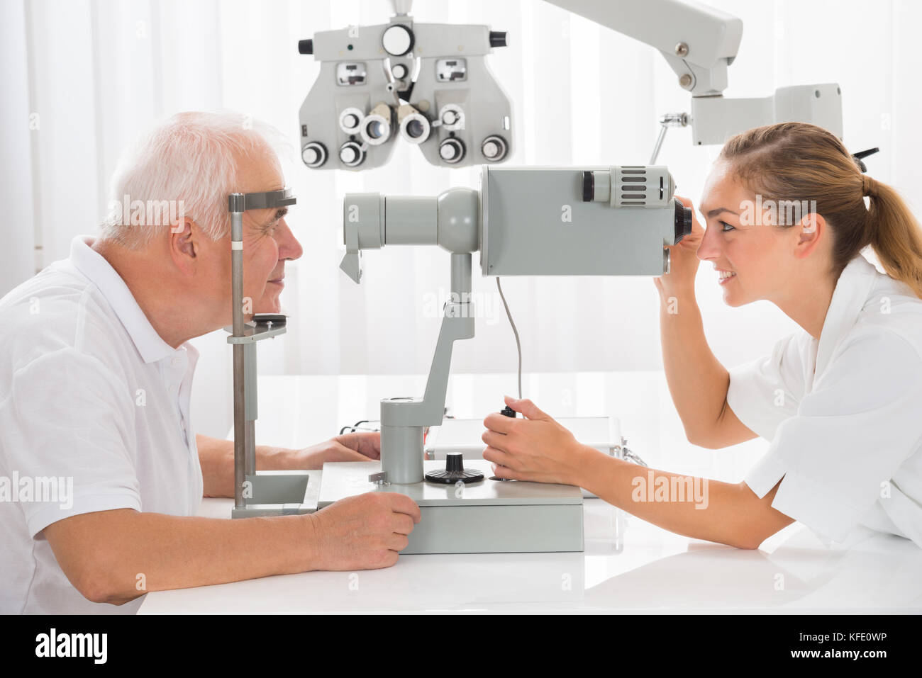 Happy Young Female Optometrist Doing Vision Testing For Senior Male ...