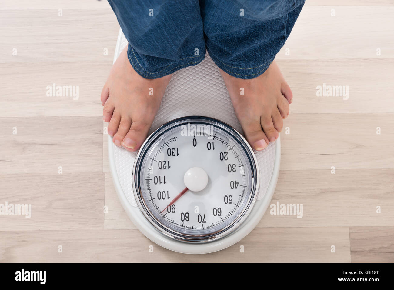 Low Section Of A Person Standing On Weighing Scale Stock Photo - Alamy