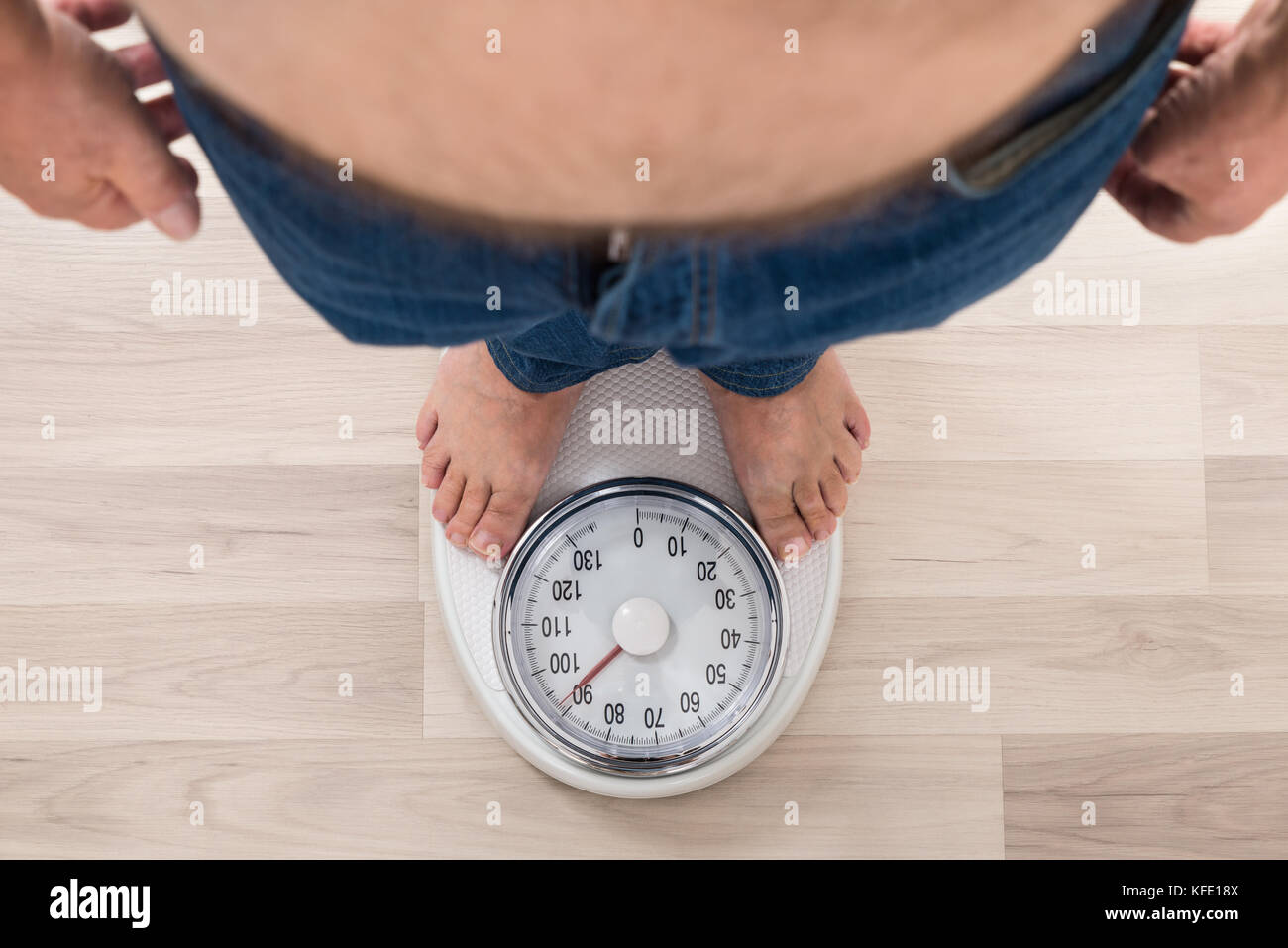 Low Section Of A Person Standing On Weighing Scale Stock Photo - Alamy