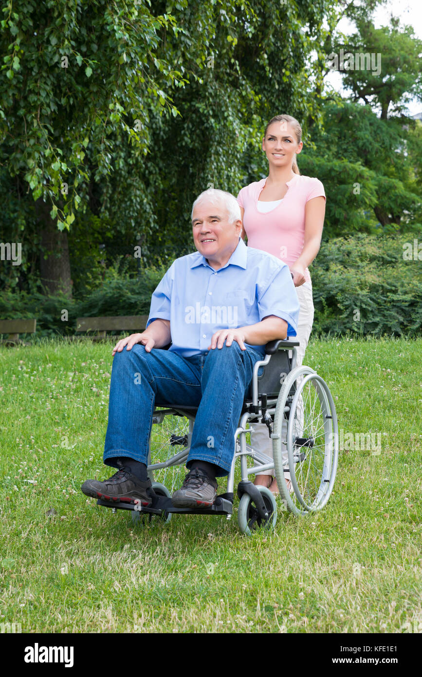 Smiling Young Woman With Her Disabled Father On Wheelchair In Park ...