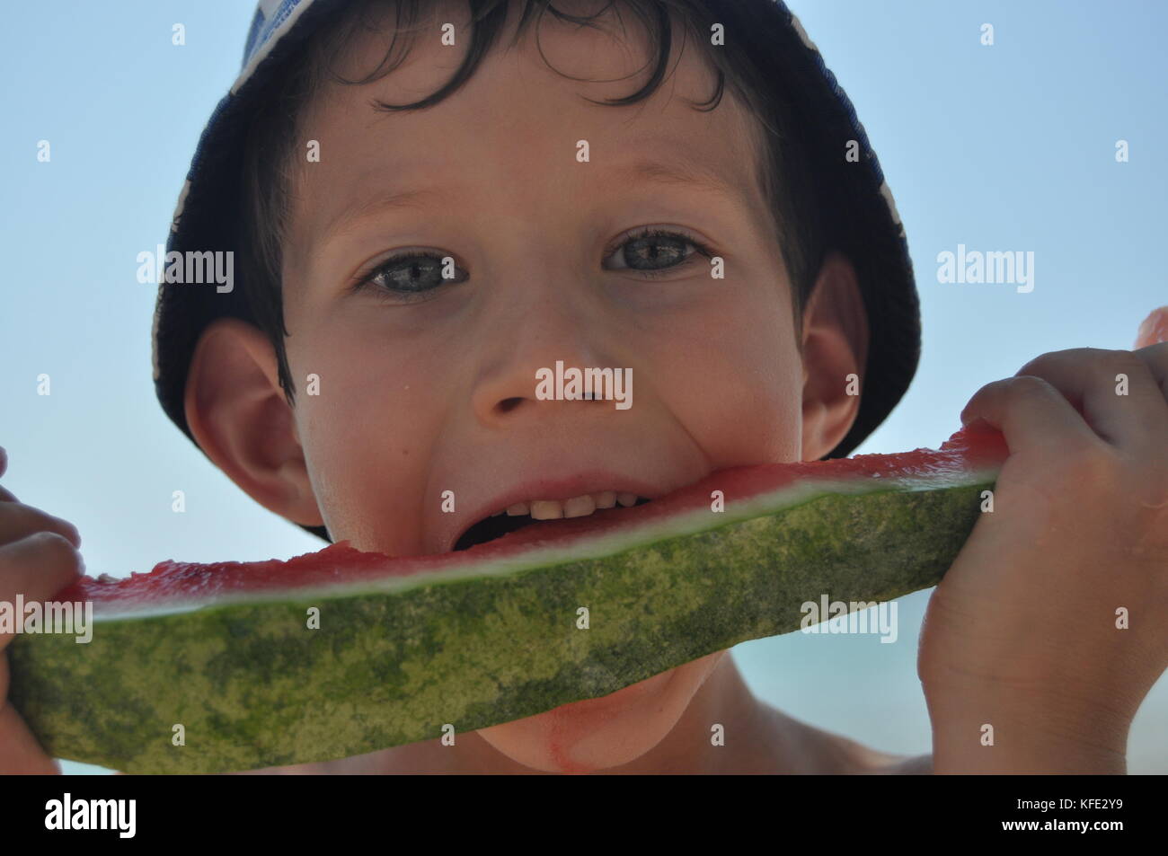 Boy in a hat sitting juicy watermelon. Exotic fruit on vacation Stock ...