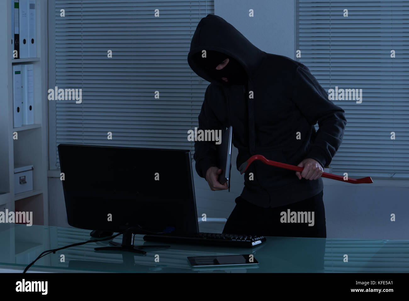 Thief Stealing Laptop From Office At Night Stock Photo - Alamy