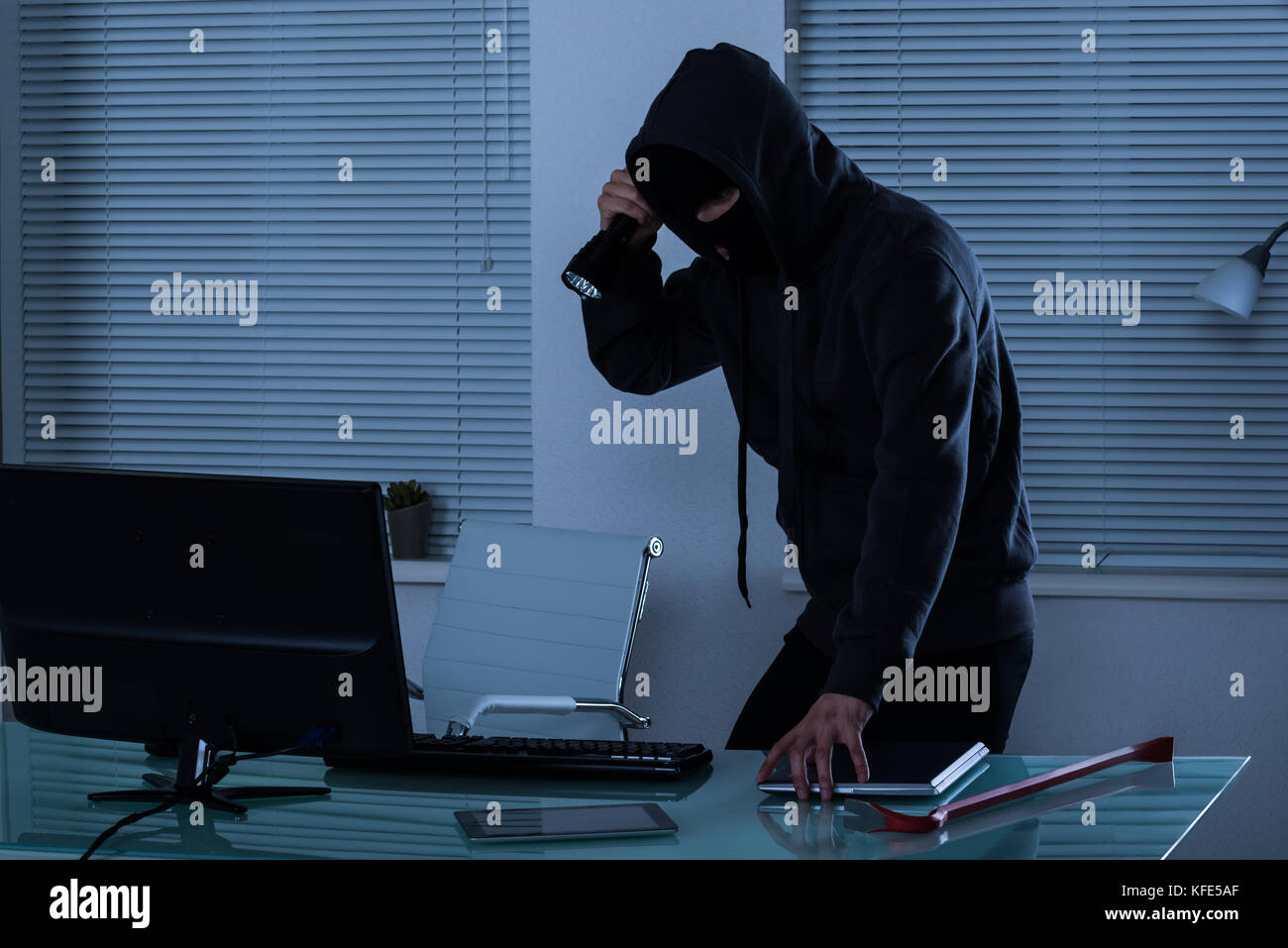Robber Stealing Laptop With Flashlight In Hand Stock Photo - Alamy