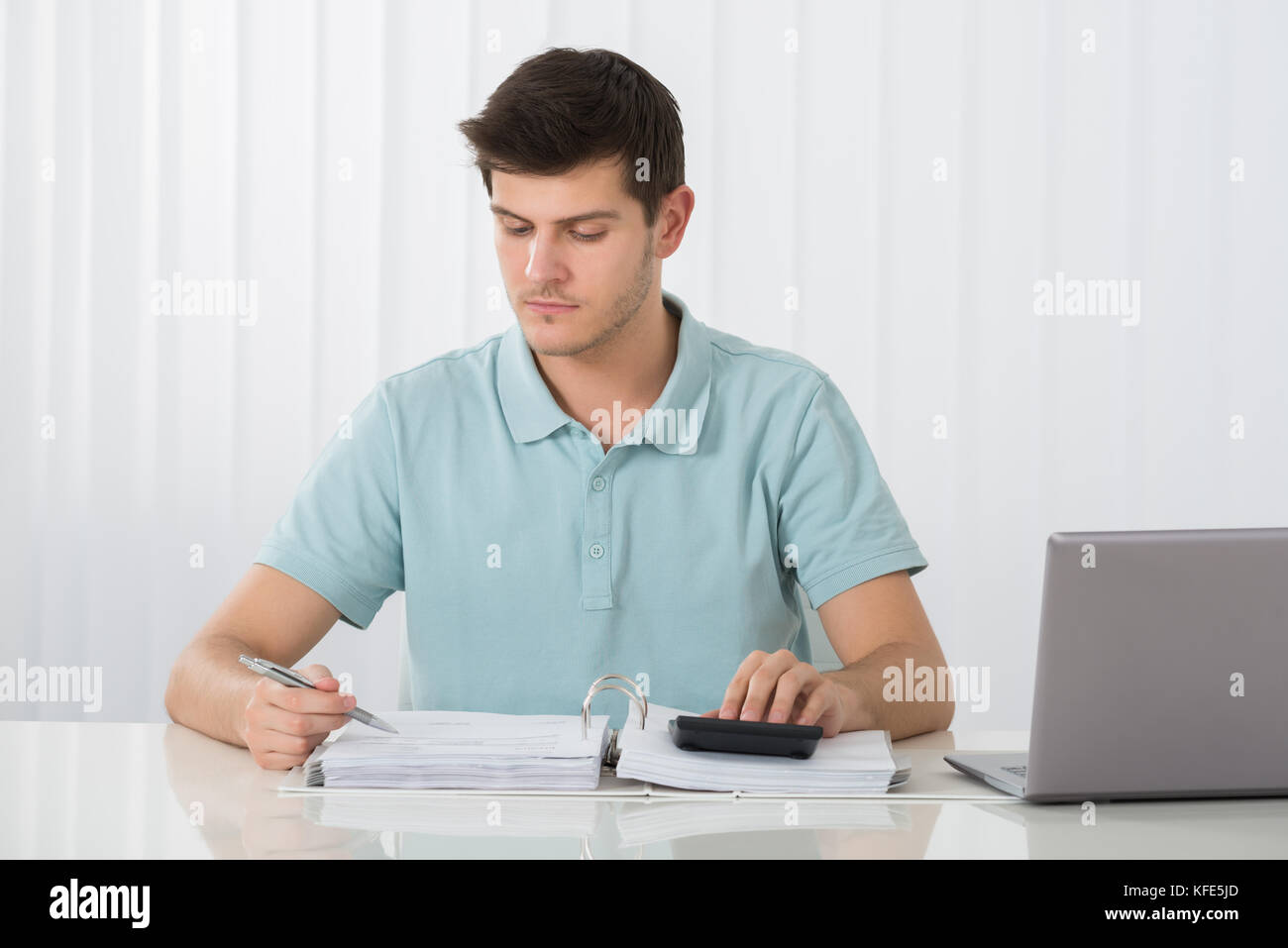 Photo Of Young Man Calculating Tax At Home Stock Photo - Alamy