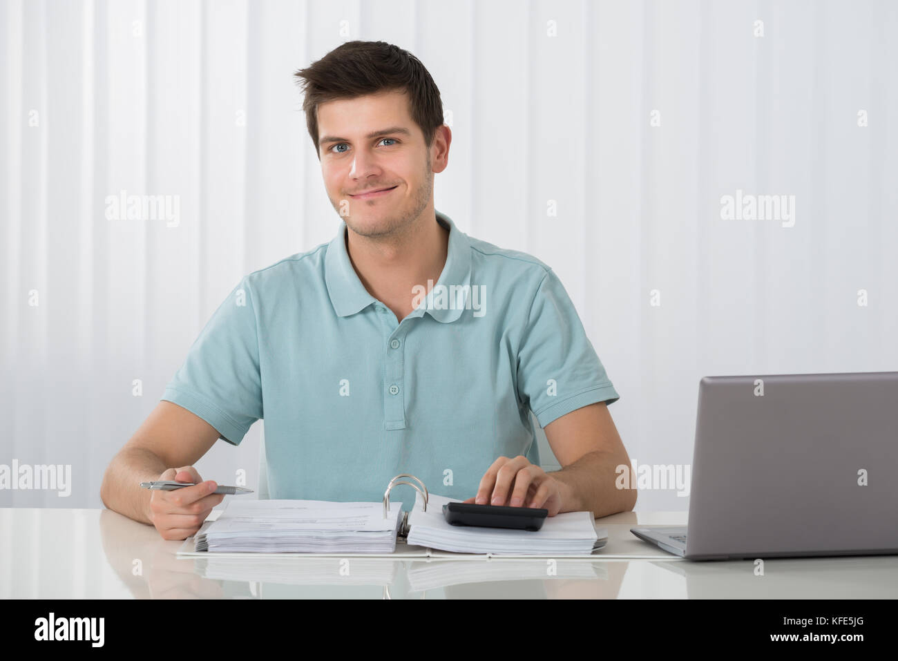 Photo Of Young Man Calculating Tax At Home Stock Photo - Alamy