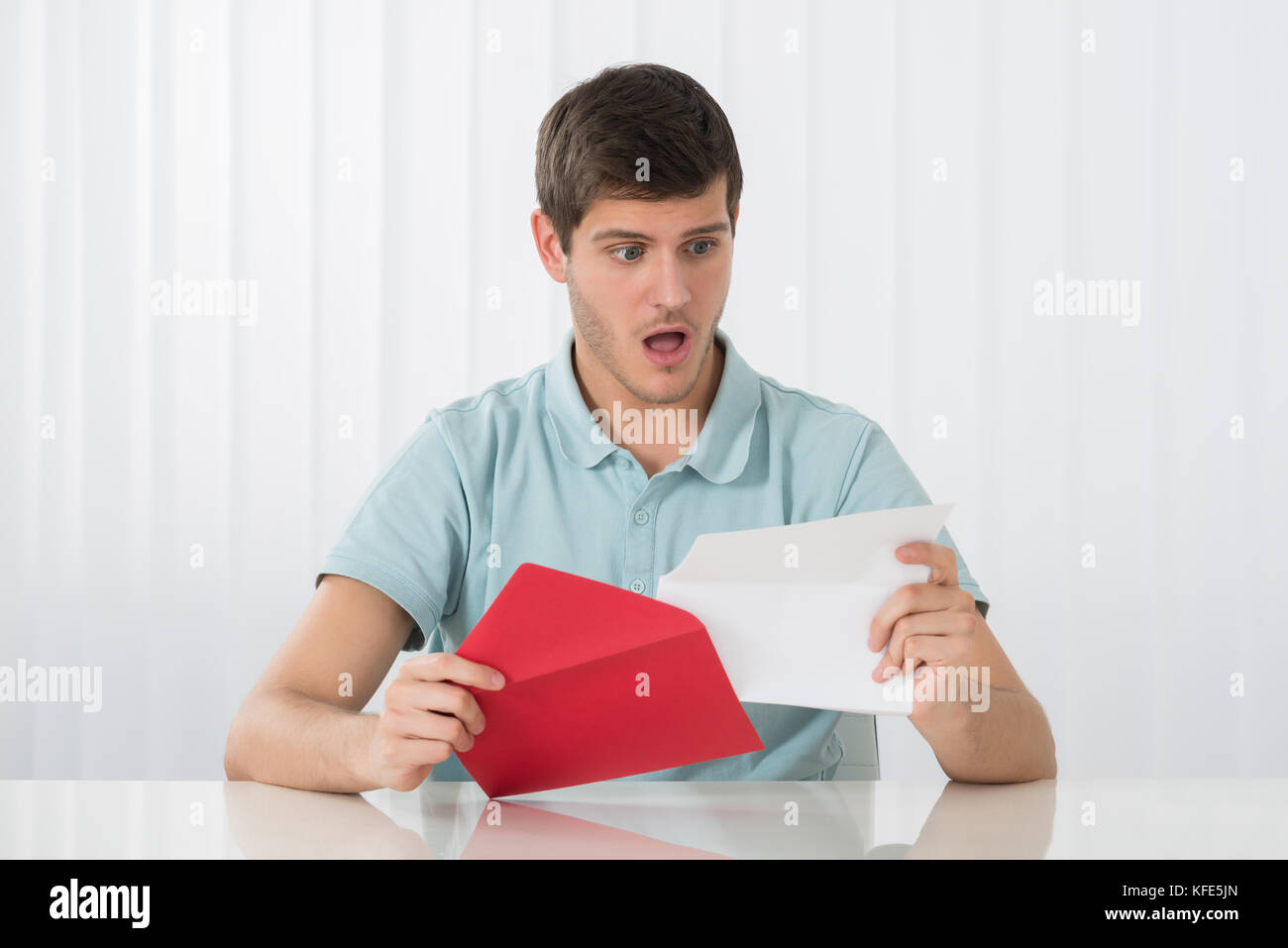 Portrait Of Surprised Young Man Looking At Letter Stock Photo - Alamy