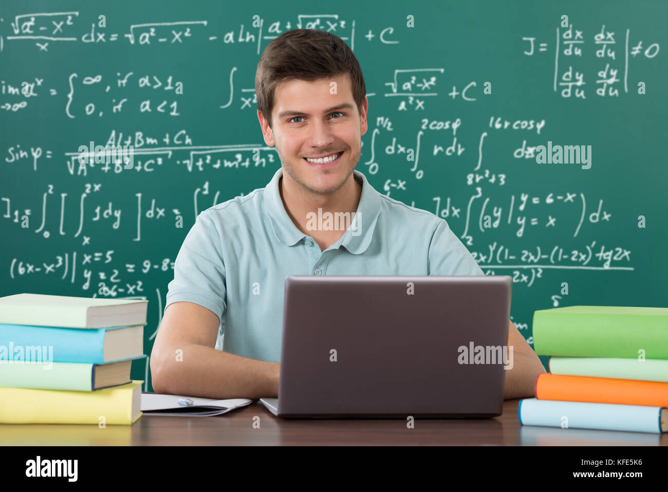 Young Man Using Laptop While Studying In Classroom Stock Photo - Alamy
