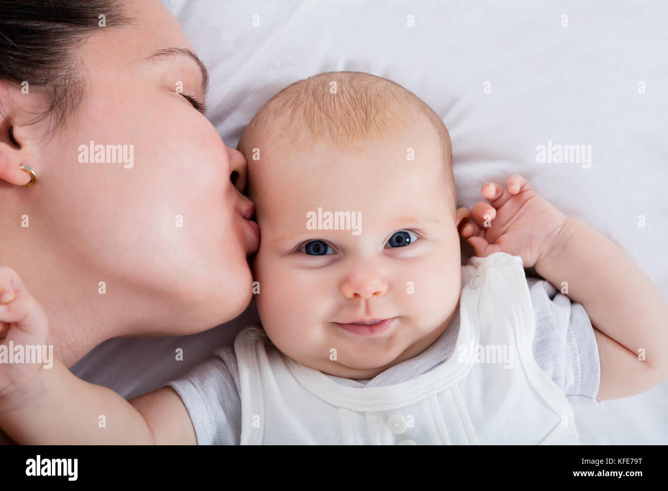 Close-up Of A Mother Kissing Her Baby On Forehead Stock Photo - Alamy