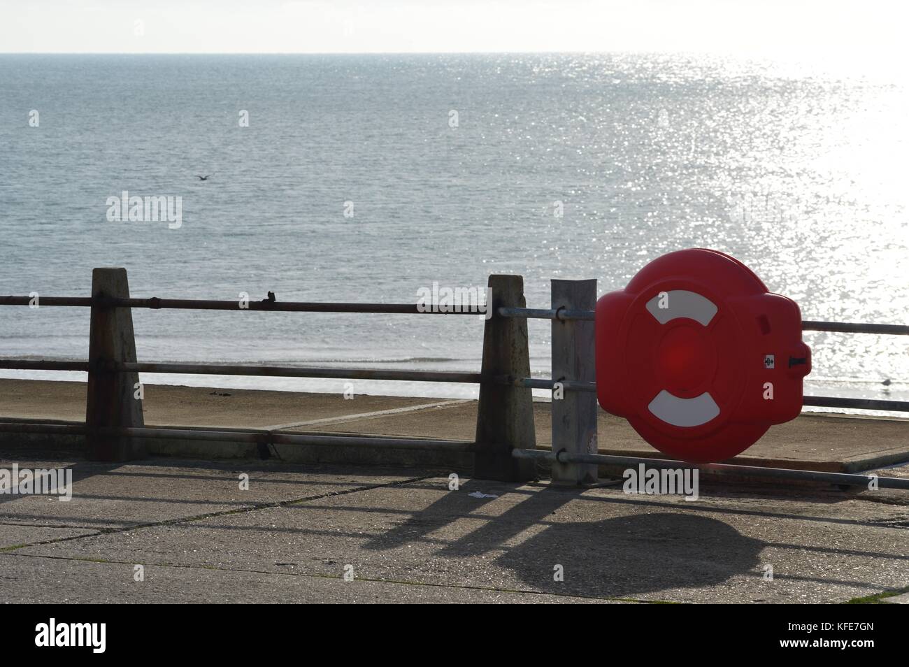 Life saver ring on railing along harbour wall Stock Photo - Alamy