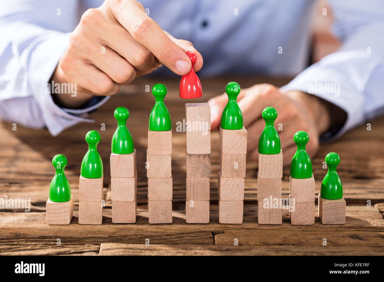 Close-up Of A Businessman Placing Red Leader Figure On Arranged Blocks ...