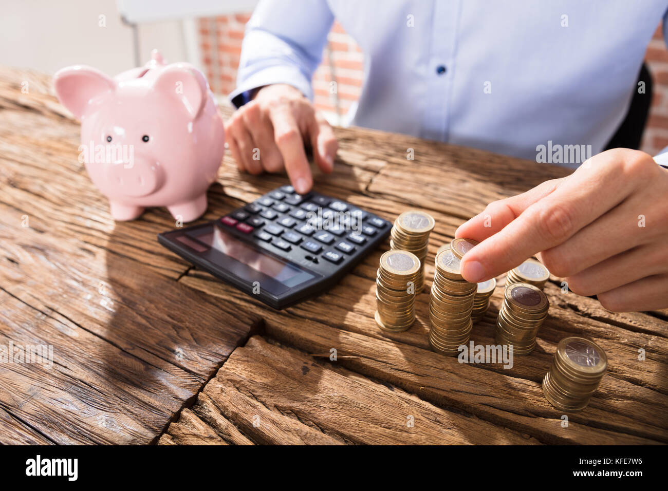 Close-up Of A Business Person Counting Coins Using Calculator With Pink ...