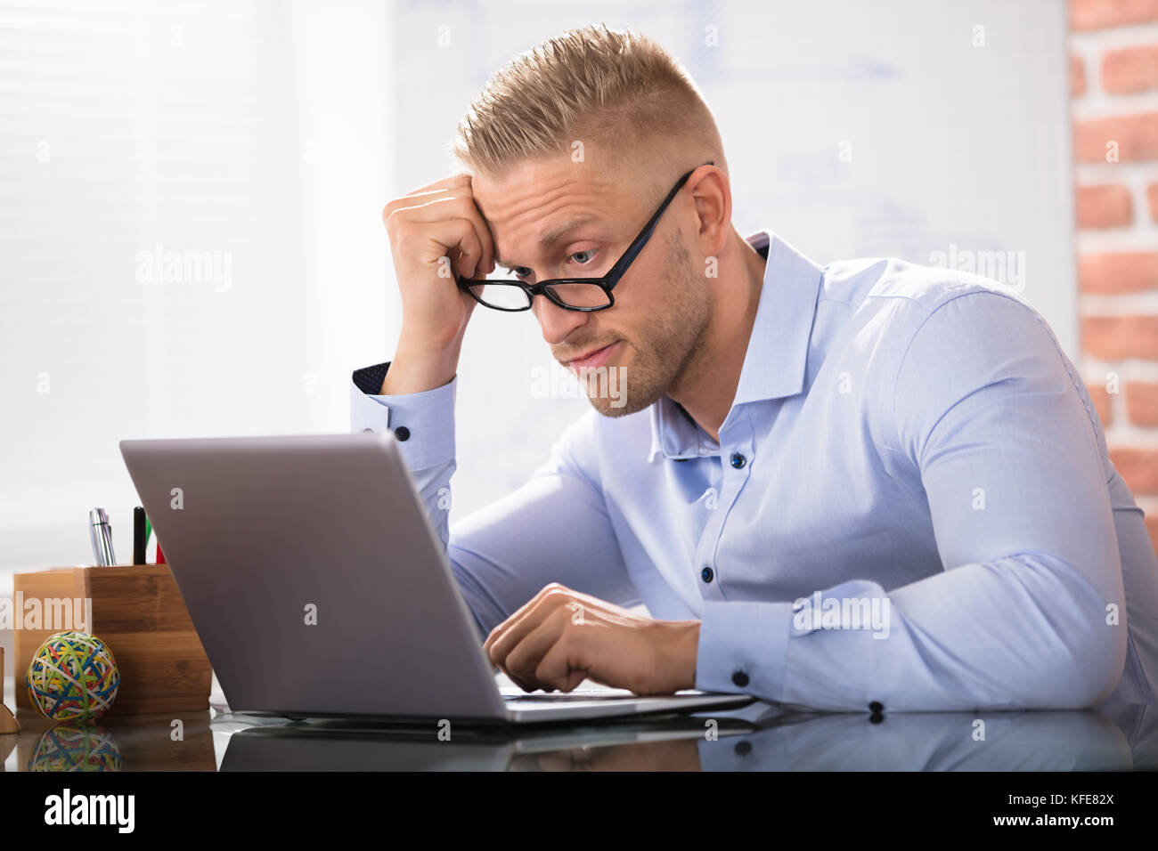 Contemplated Businessman Sitting With Laptop At Workplace Stock Photo ...