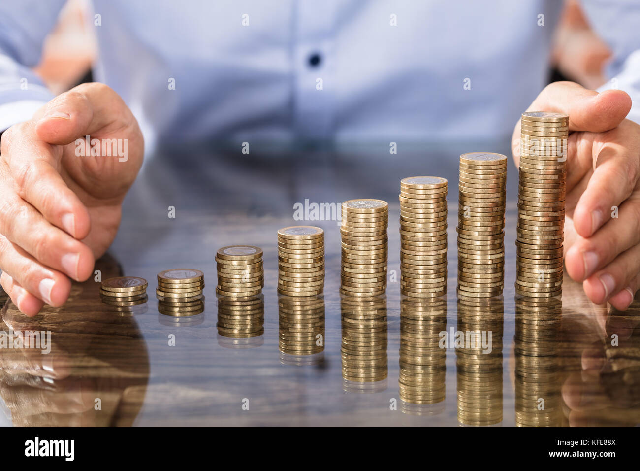 Close-up Of A Person Holding Increasing Stack Of Gold Coins Over The ...