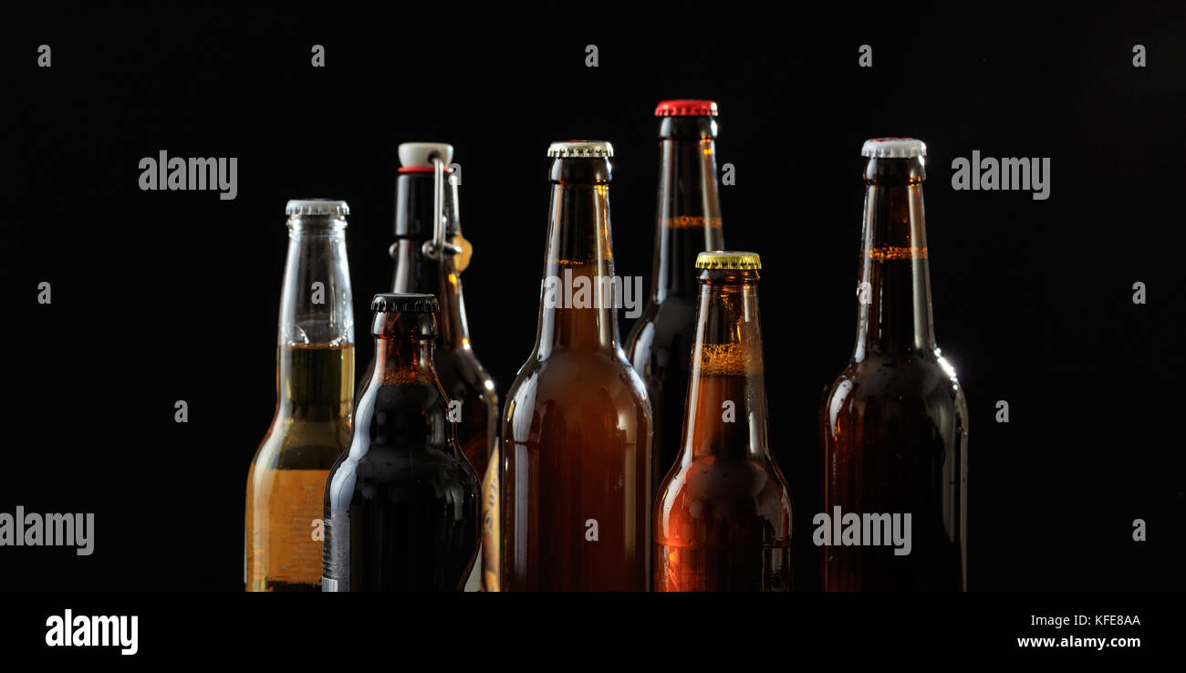 Collection of unopened beer bottles on black background Stock Photo - Alamy