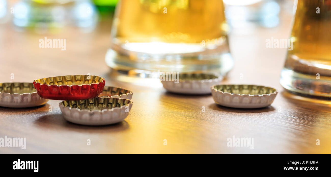 Beer caps and glasses of beer on a pub background. Closeup on the beer ...