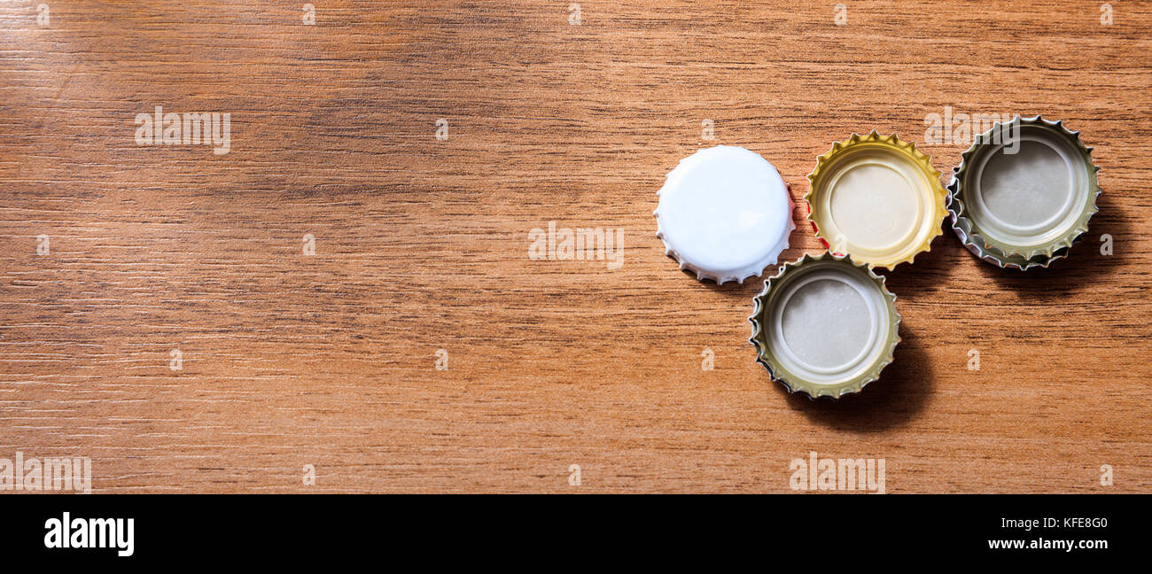 Beer caps on wooden background. Top view, copy space Stock Photo - Alamy