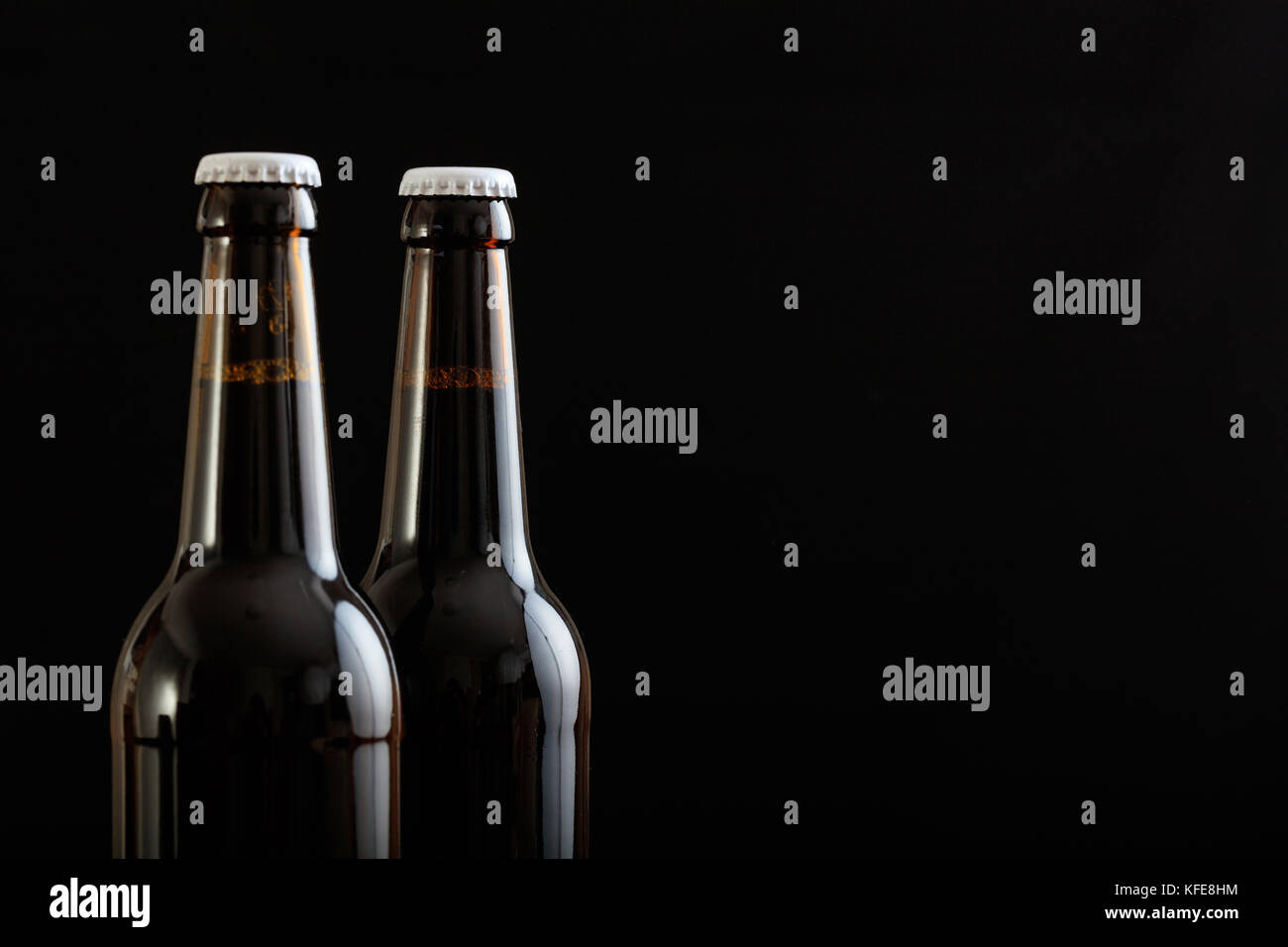 Closeup of two unopened beer bottles isolated on black background Stock ...