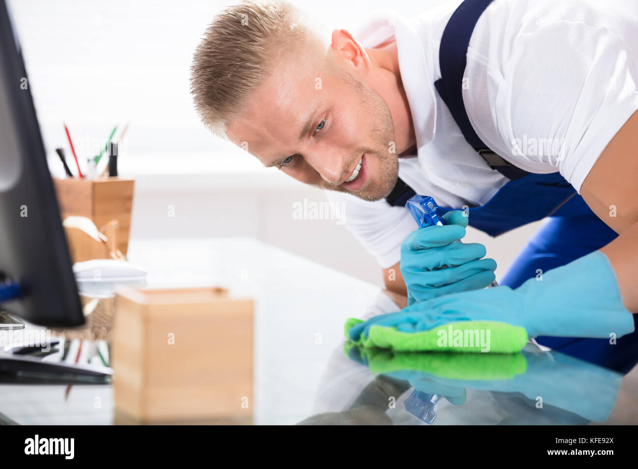 Close-up Of A Young Male Janitor Cleaning Desk With Green Cloth Stock ...