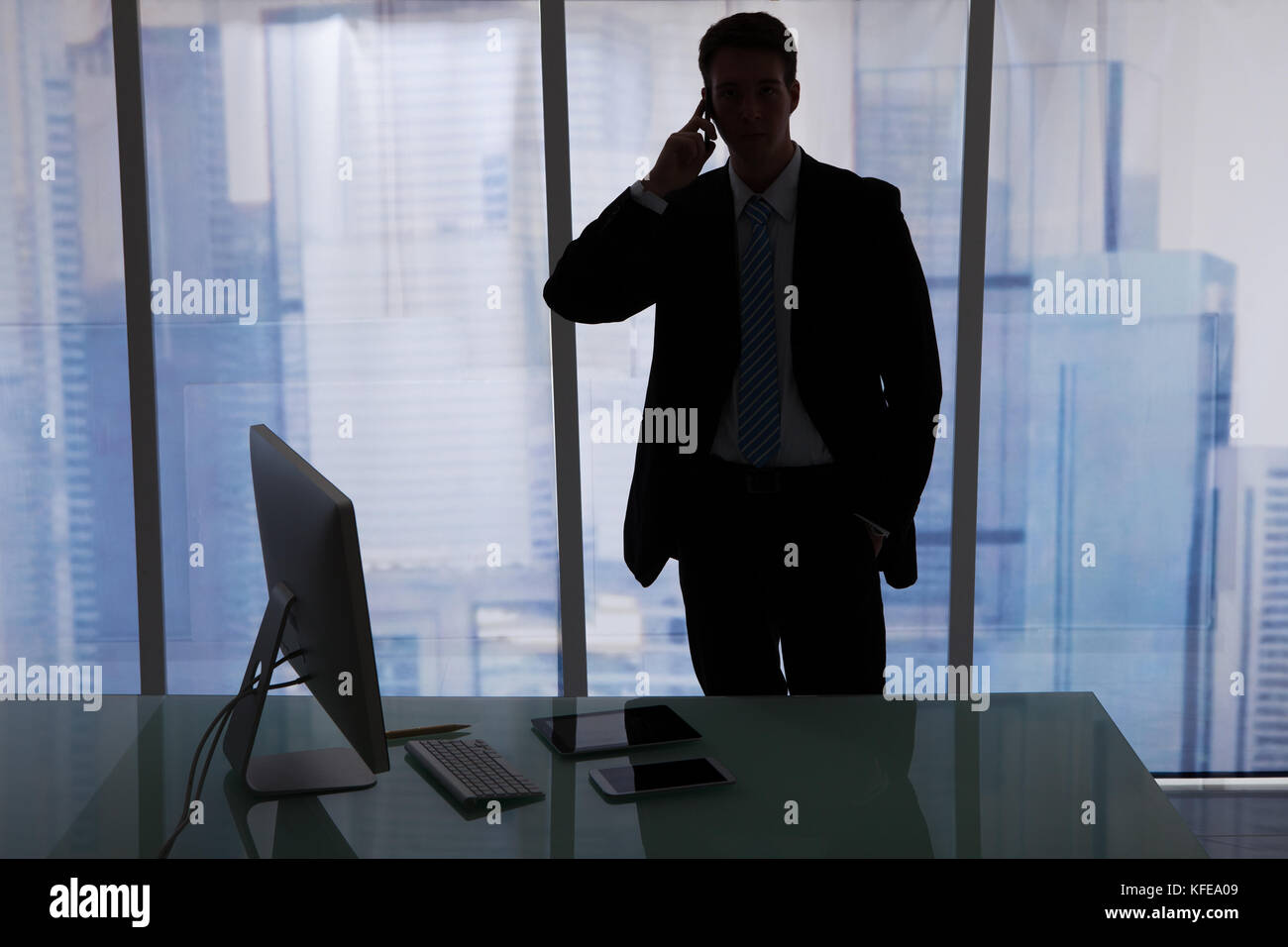 Young businessman using cell phone at office desk Stock Photo - Alamy