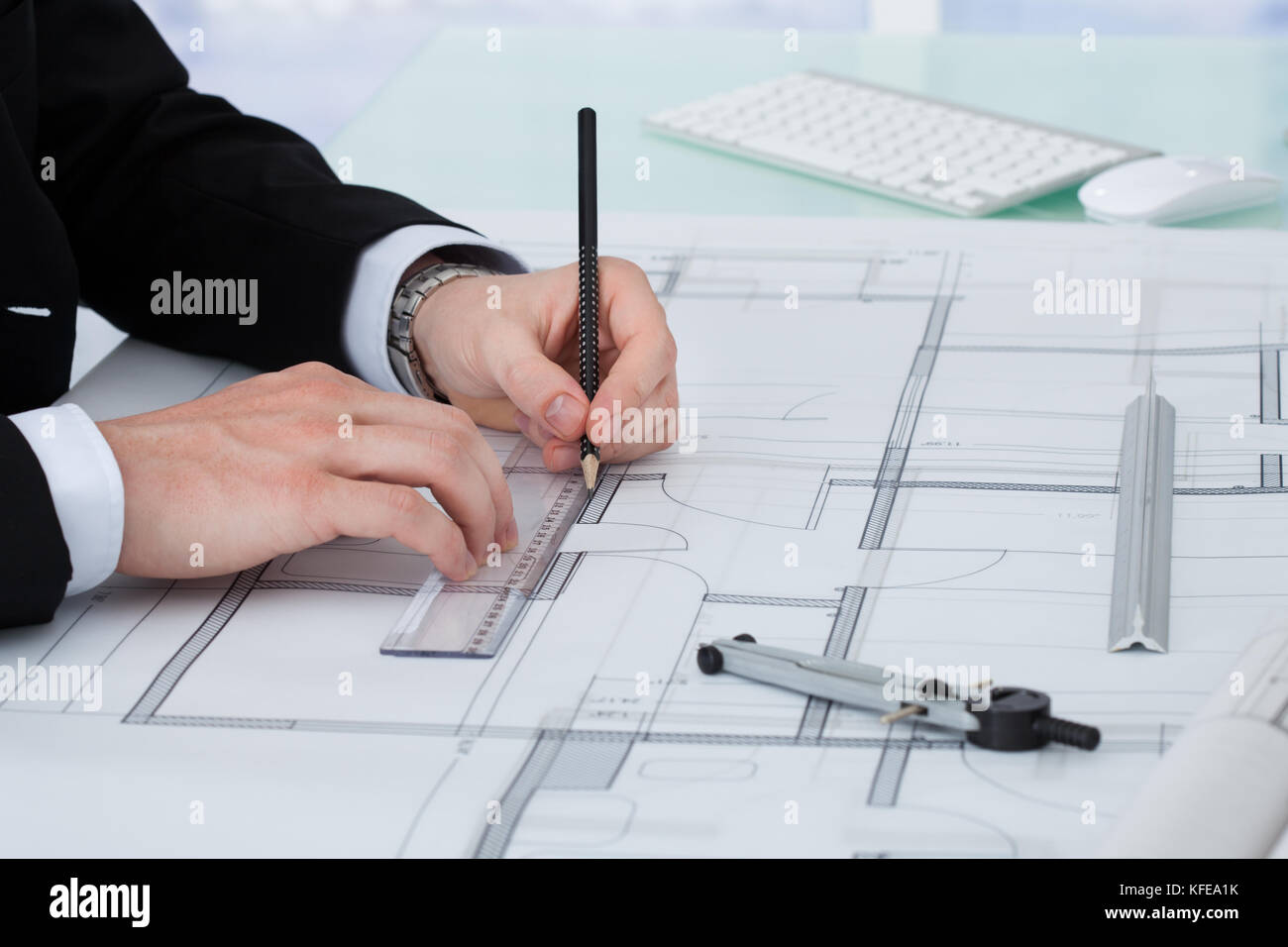 Cropped image of businessman working on blueprint at desk in office ...