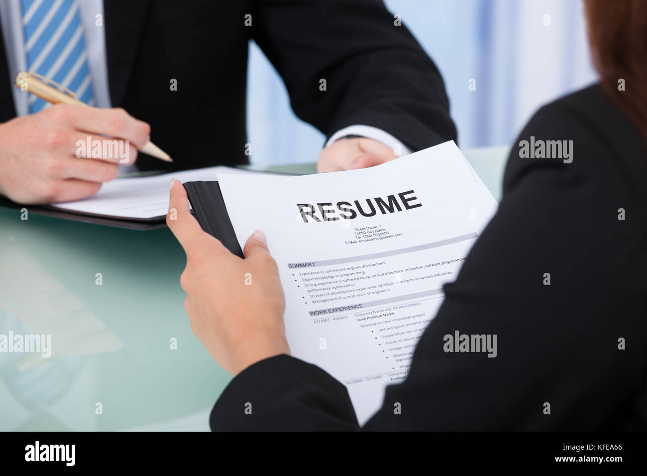 Cropped image of female candidate holding resume at desk during ...