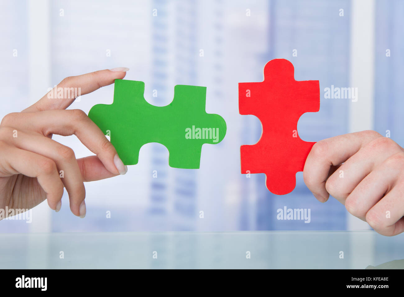 Cropped image of business people joining jigsaw pieces in office Stock ...