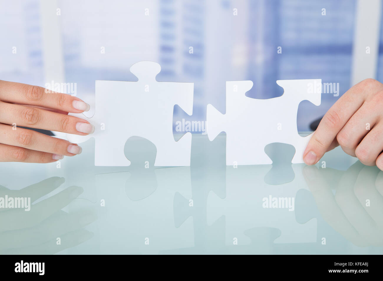 Cropped image of business people joining jigsaw pieces in office Stock ...