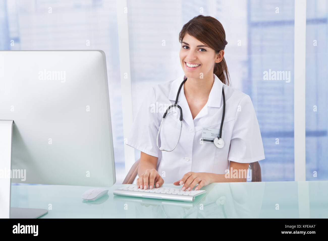 Portrait of young female doctor using computer at desk in clinic Stock ...