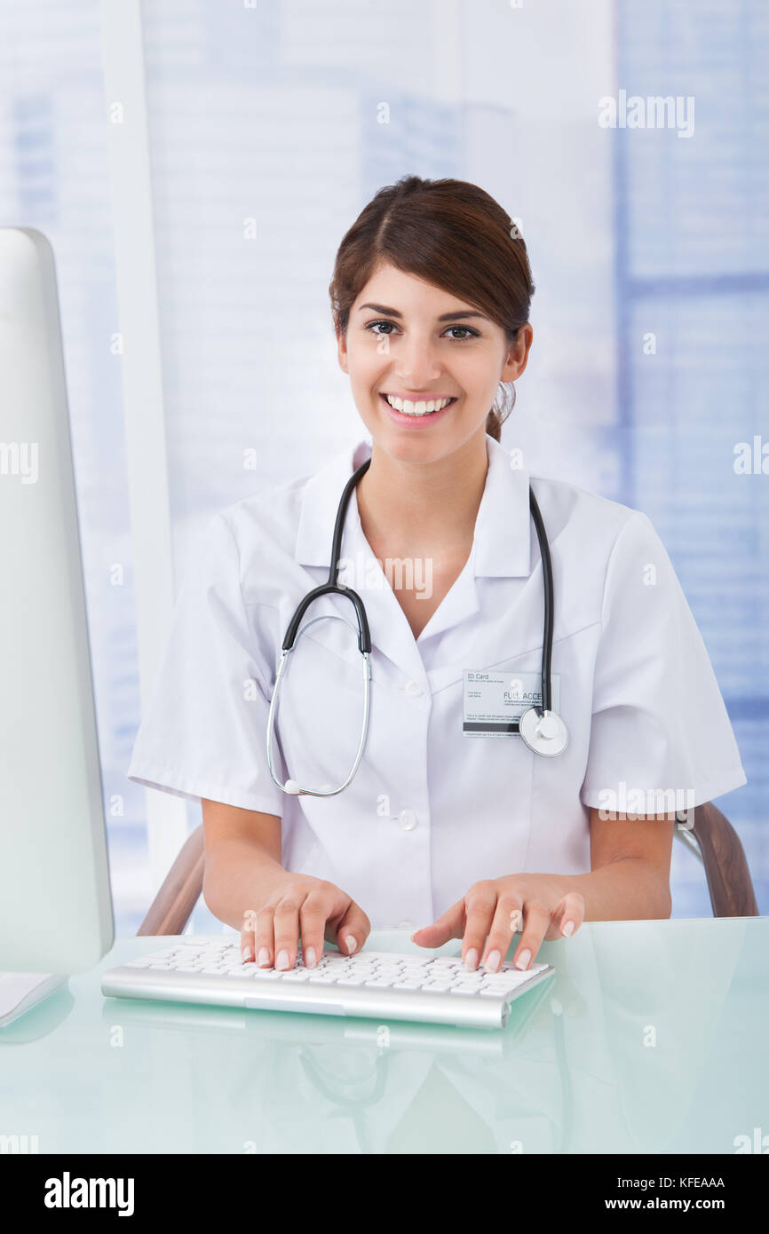 Portrait of young female doctor using computer at desk in clinic Stock ...