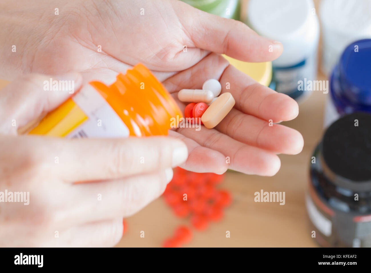 A woman pours the pills, vitamin and supplement out of the bottle into ...