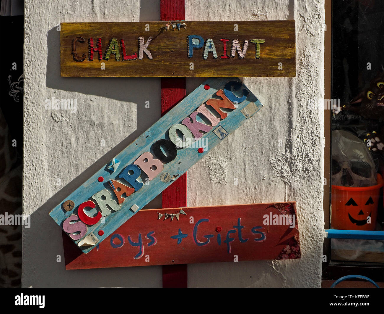 wonky brightly painted multi-coloured wooden signs outside a shop in ...