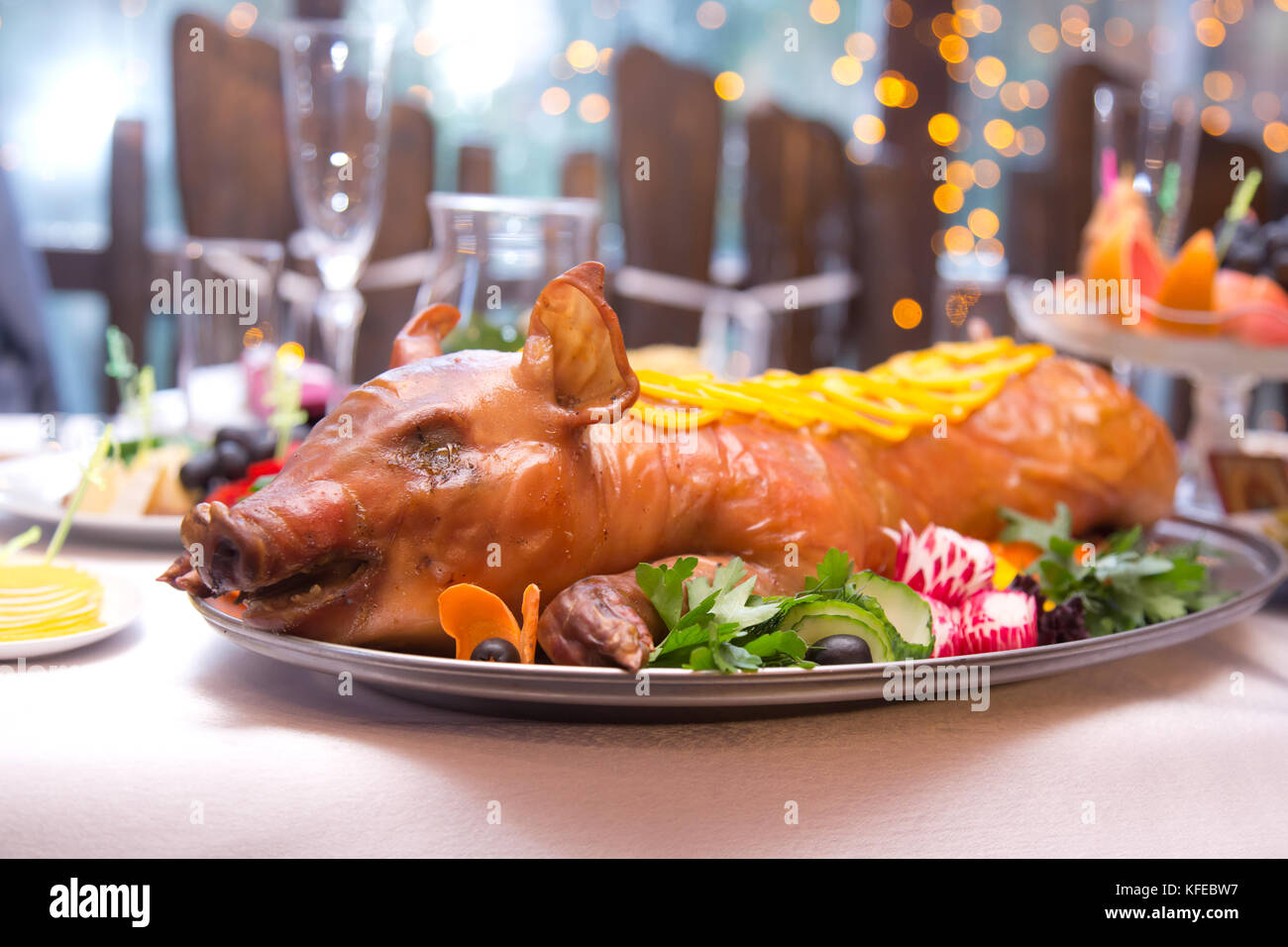 Roast pig. Roasted piglet with vegetables on platter Stock Photo - Alamy