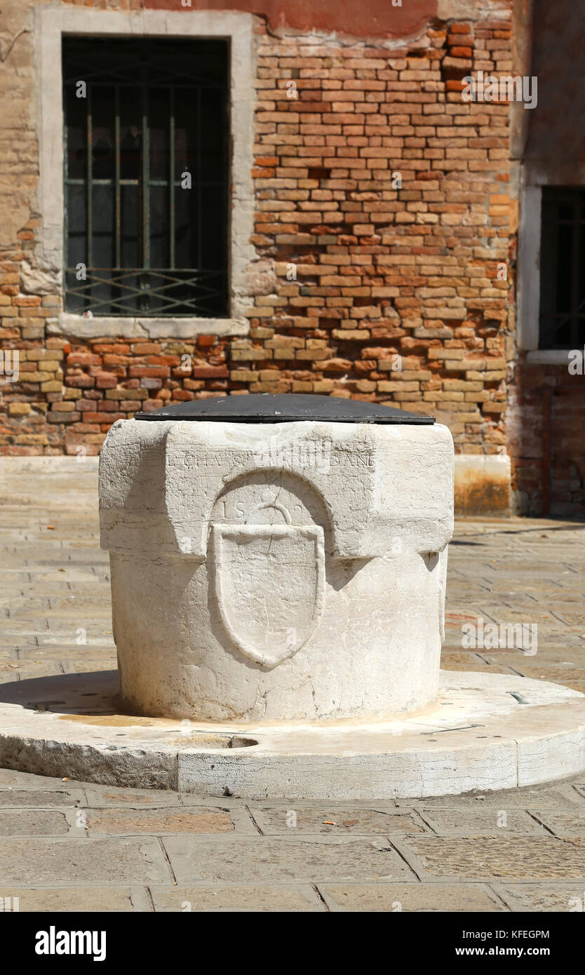 very ancient stone well in a square of a European city Stock Photo - Alamy